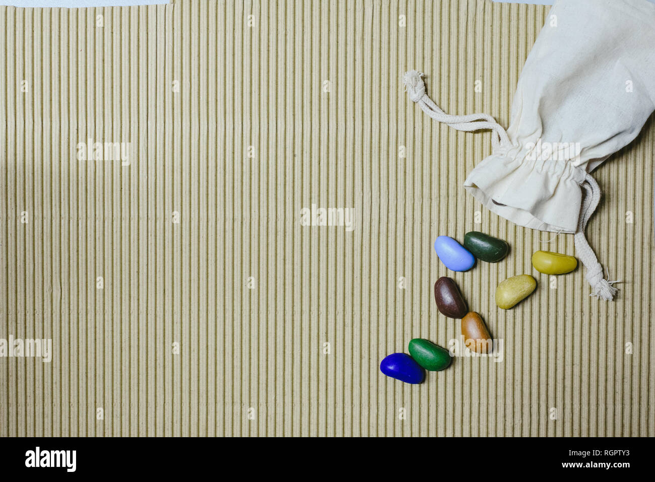 Background of colored fake stones scattered on a wavy paper with cloth ...
