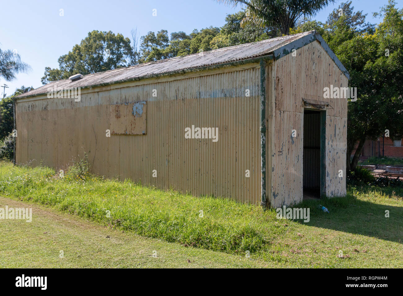 A close up side view of a old rusted run down metal barn or storage ...