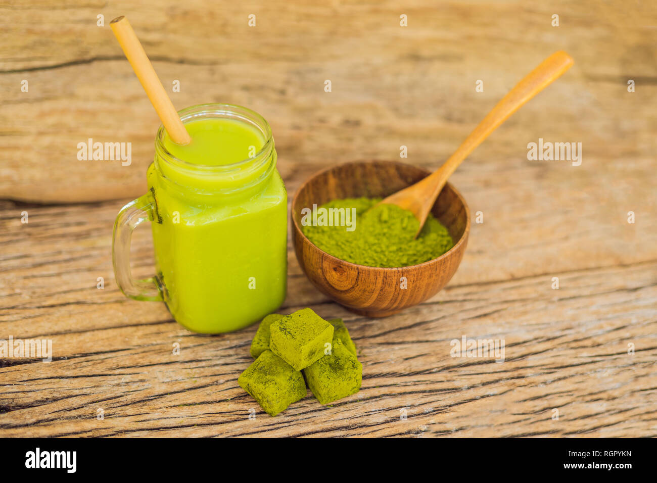 Green tea latte with ice in mason jar, matcha powder and candy made of ...