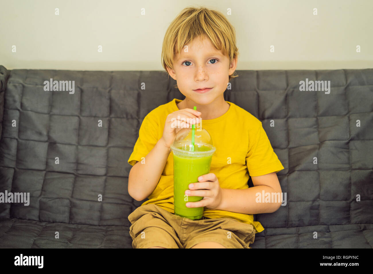 The boy is drinking Green tea latte with ice in mason jar. Homemade ...