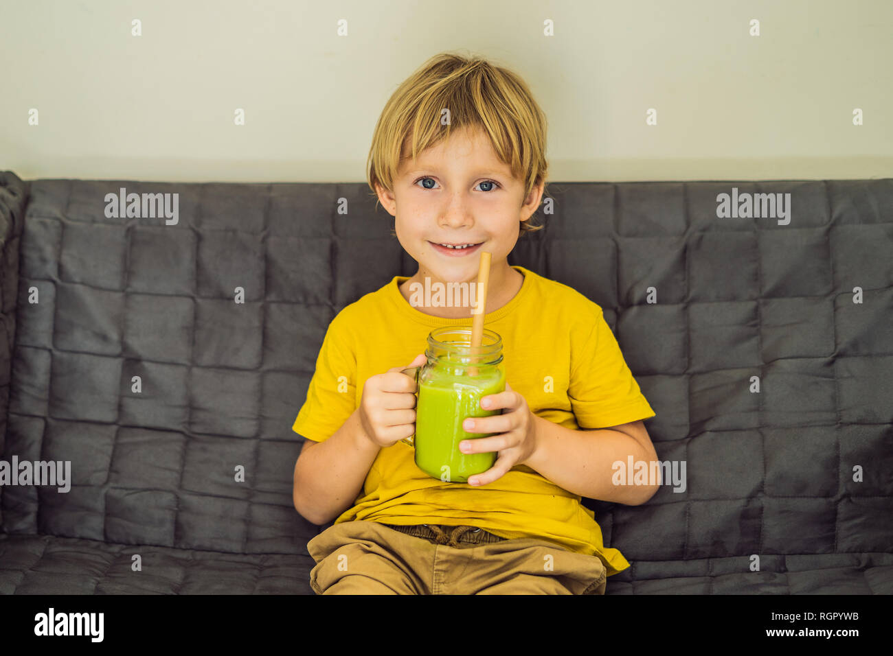 The boy is drinking Green tea latte with ice in mason jar. Homemade ...