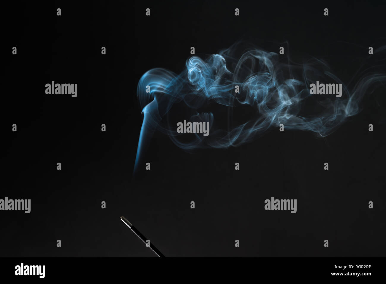 Smoking incense stick with smoke going up on Black Background. Pure ...