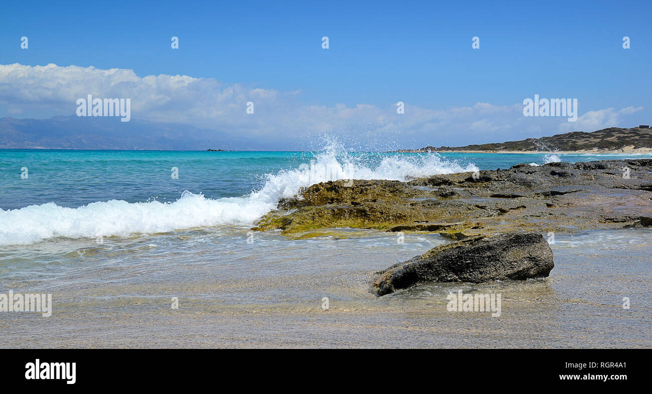 big stones on the sand on the shore, the waves break on the rocks, in ...