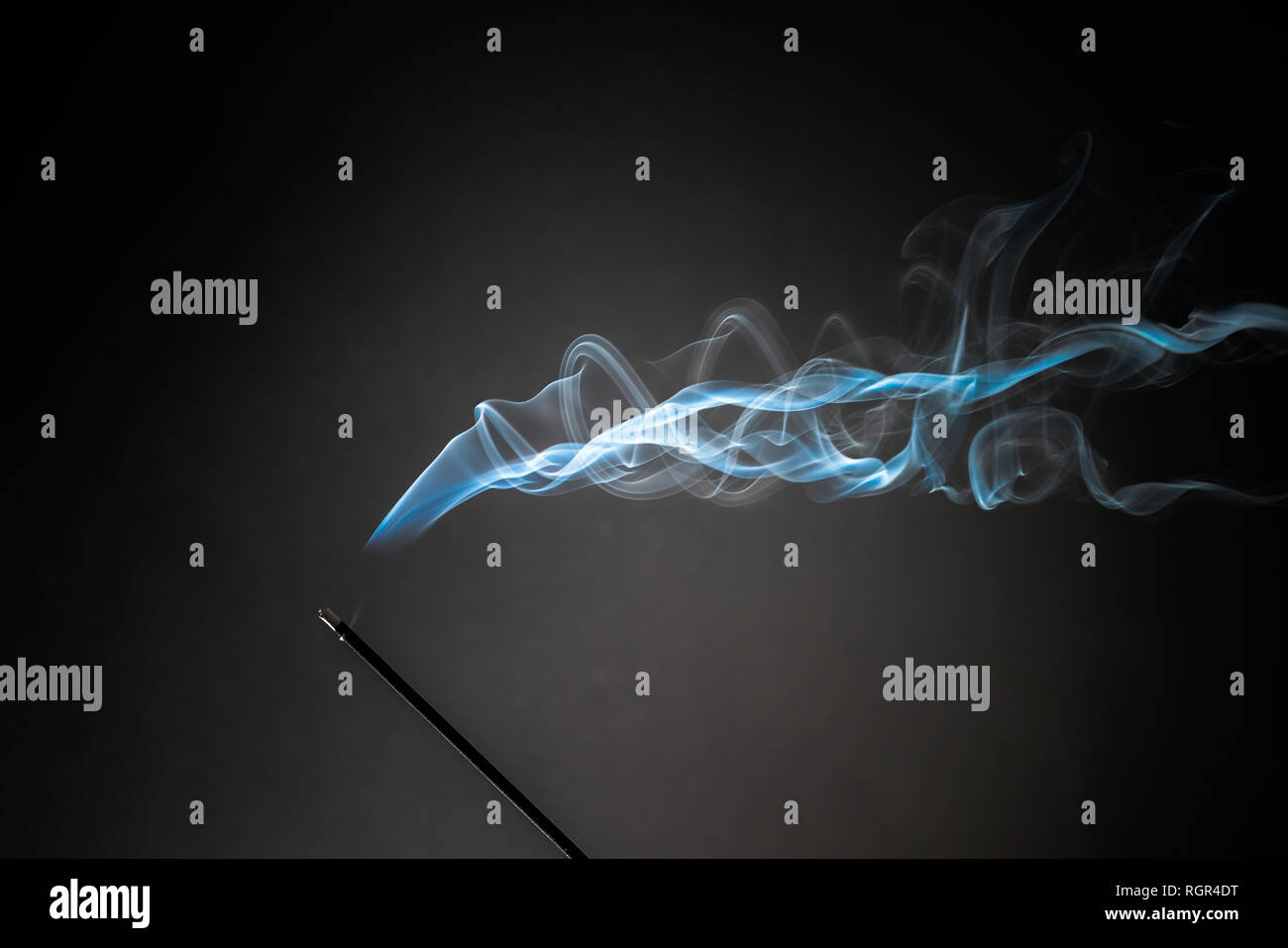 Smoking incense stick with smoke going up on Black Background. Pure ...
