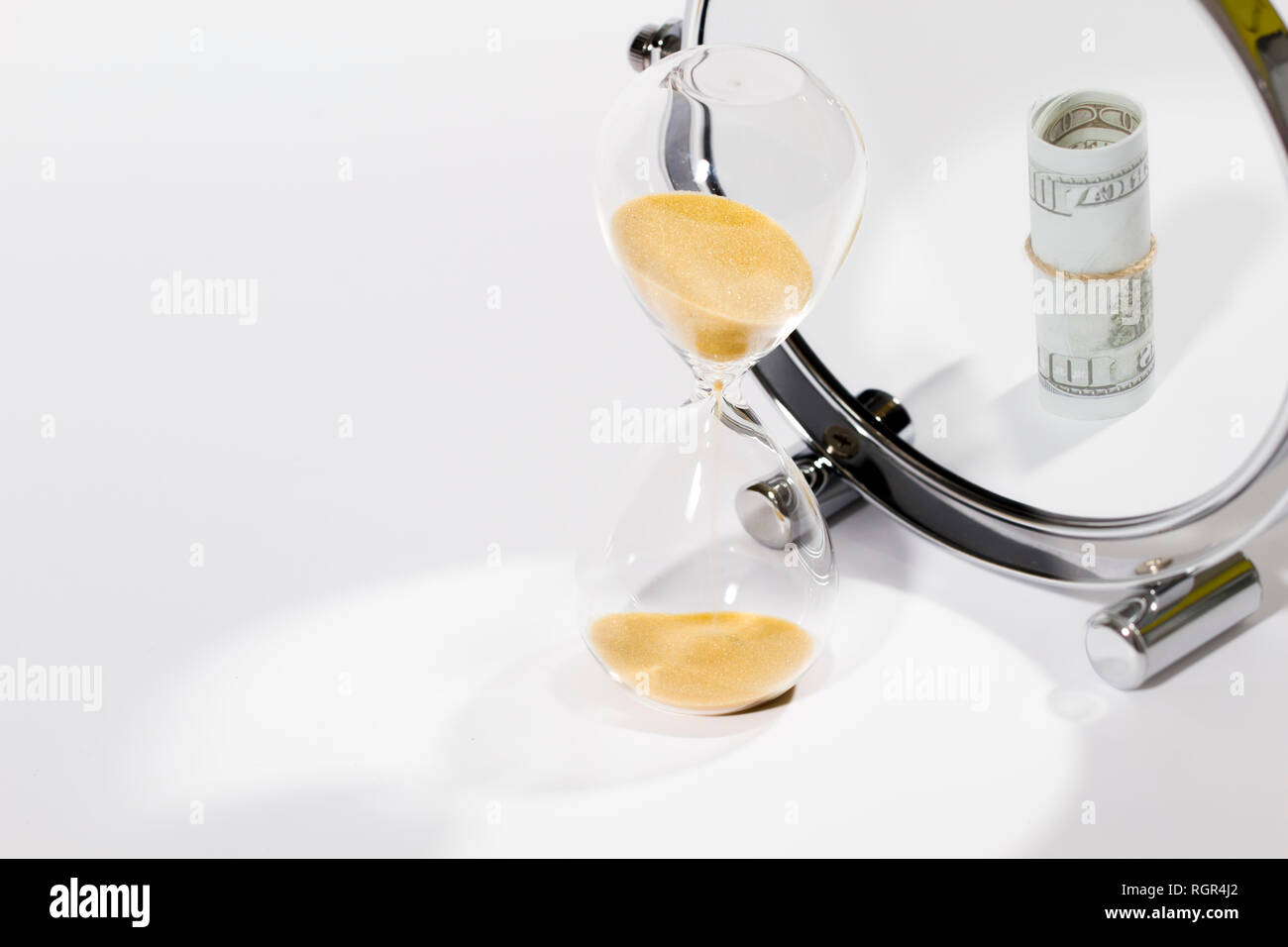 Money and realistic hourglass in the mirror Stock Photo - Alamy