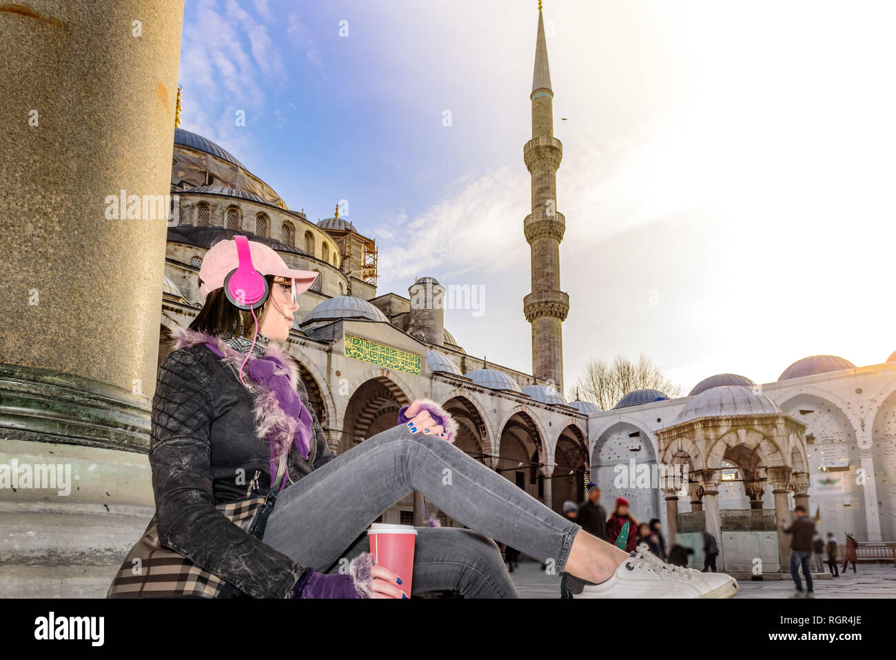 Beautiful woman in hat with takeaway coffee sunglasses,headphones sits ...
