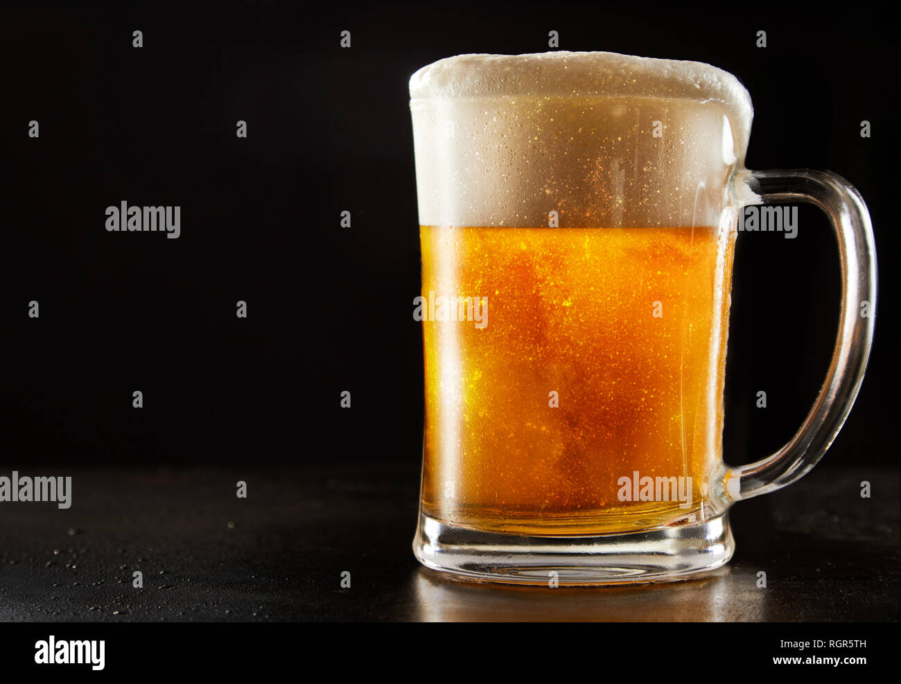 Large glass mug of effervescent chilled glitter draft beer with a good ...