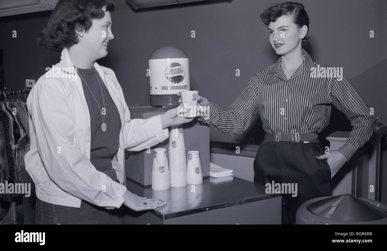 1950s, USA, a lady been given a plastic cup of draught Pepsi-Cola,, the ...