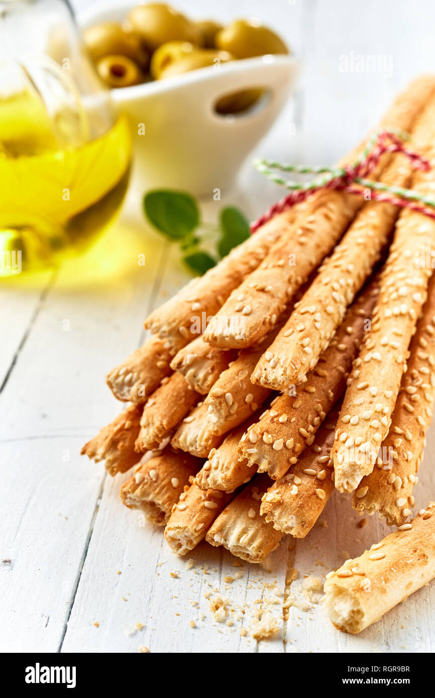Crunchy dried sesame grissini breadsticks with olive oil for dipping in ...