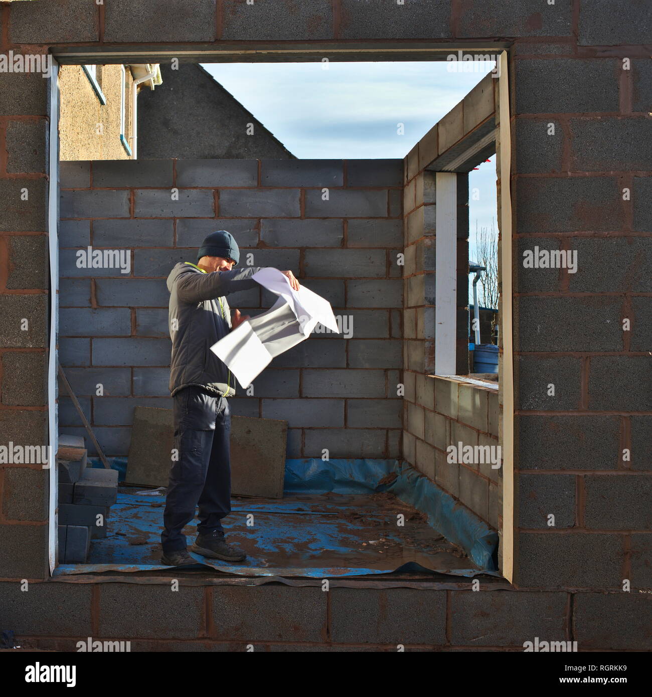 Builder working on home extension project built with block cavity walls ...