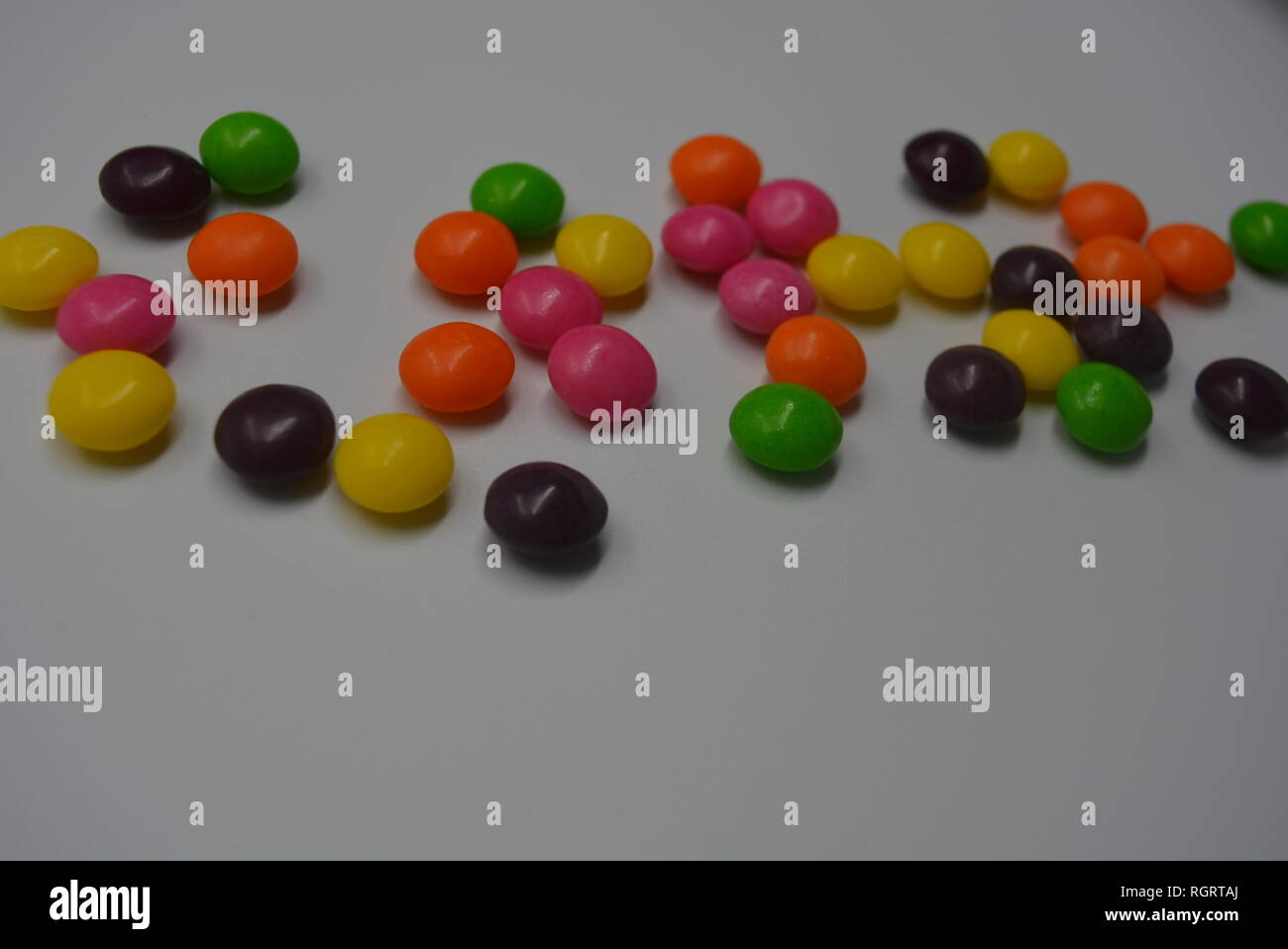 Bright sweet and tasty candies, yellow, pink, orange, green and purple ...