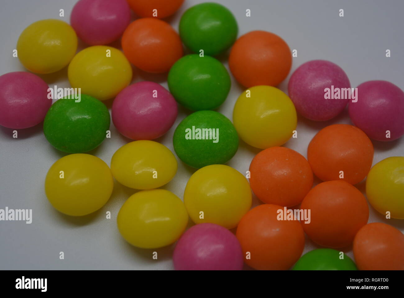 Bright sweet and tasty candies, yellow, pink, orange, green and purple ...