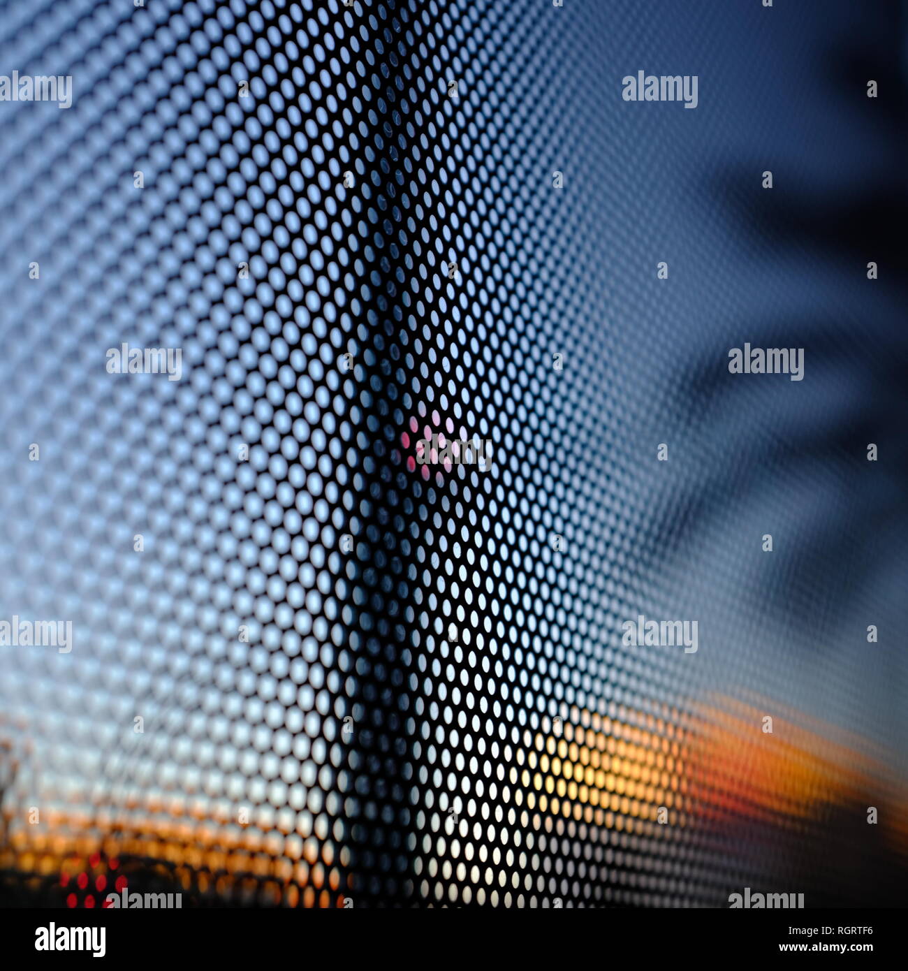 Abstract shot through mesh screen on bus with traffic lights and palm ...