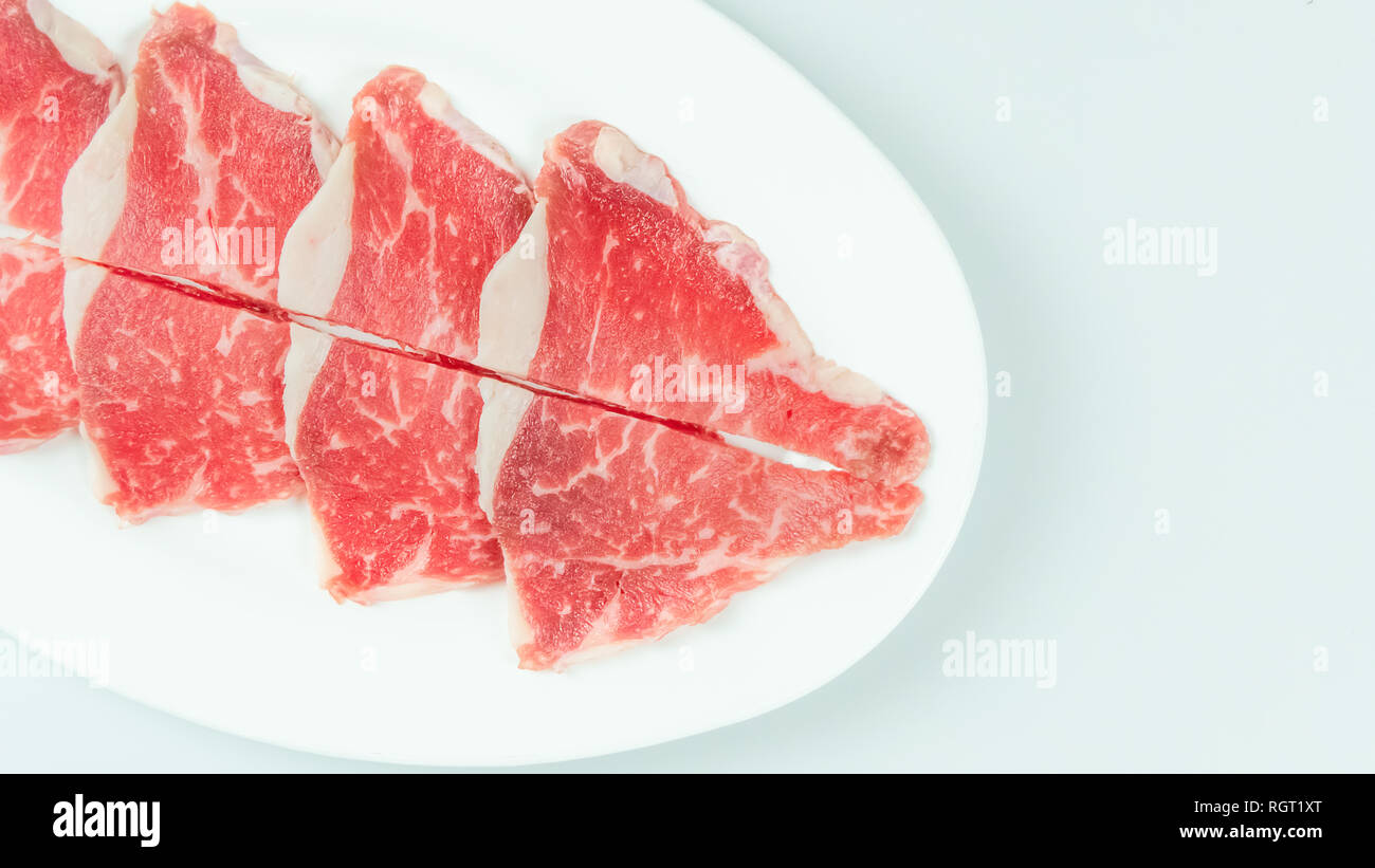 Top view of some raw beef on a plate over white background Stock Photo ...