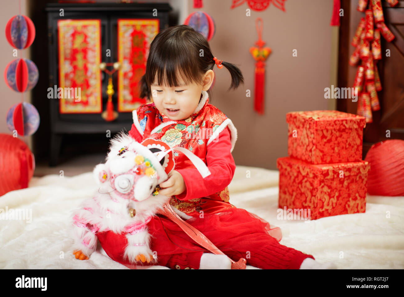 Chinese baby girl traditional dressing up holding a dance loin toy with ...