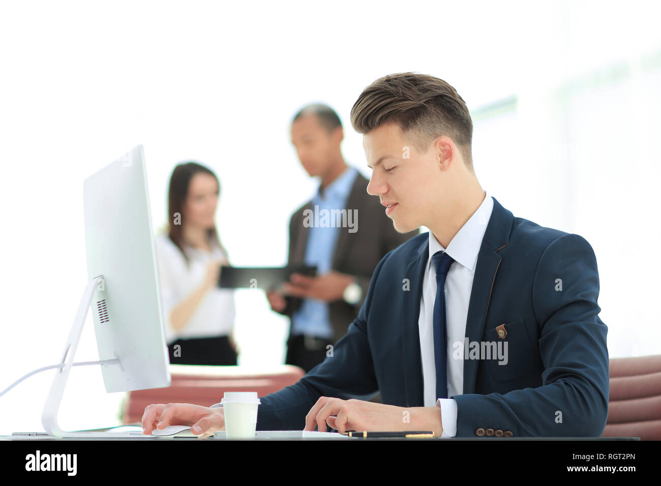 employee sitting behind a Desk in the office Stock Photo - Alamy
