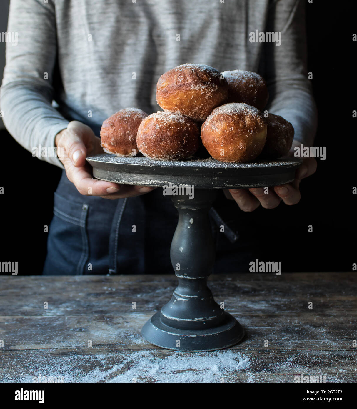 Crop human holding tray with set of fresh cakes with powdered sugar on ...