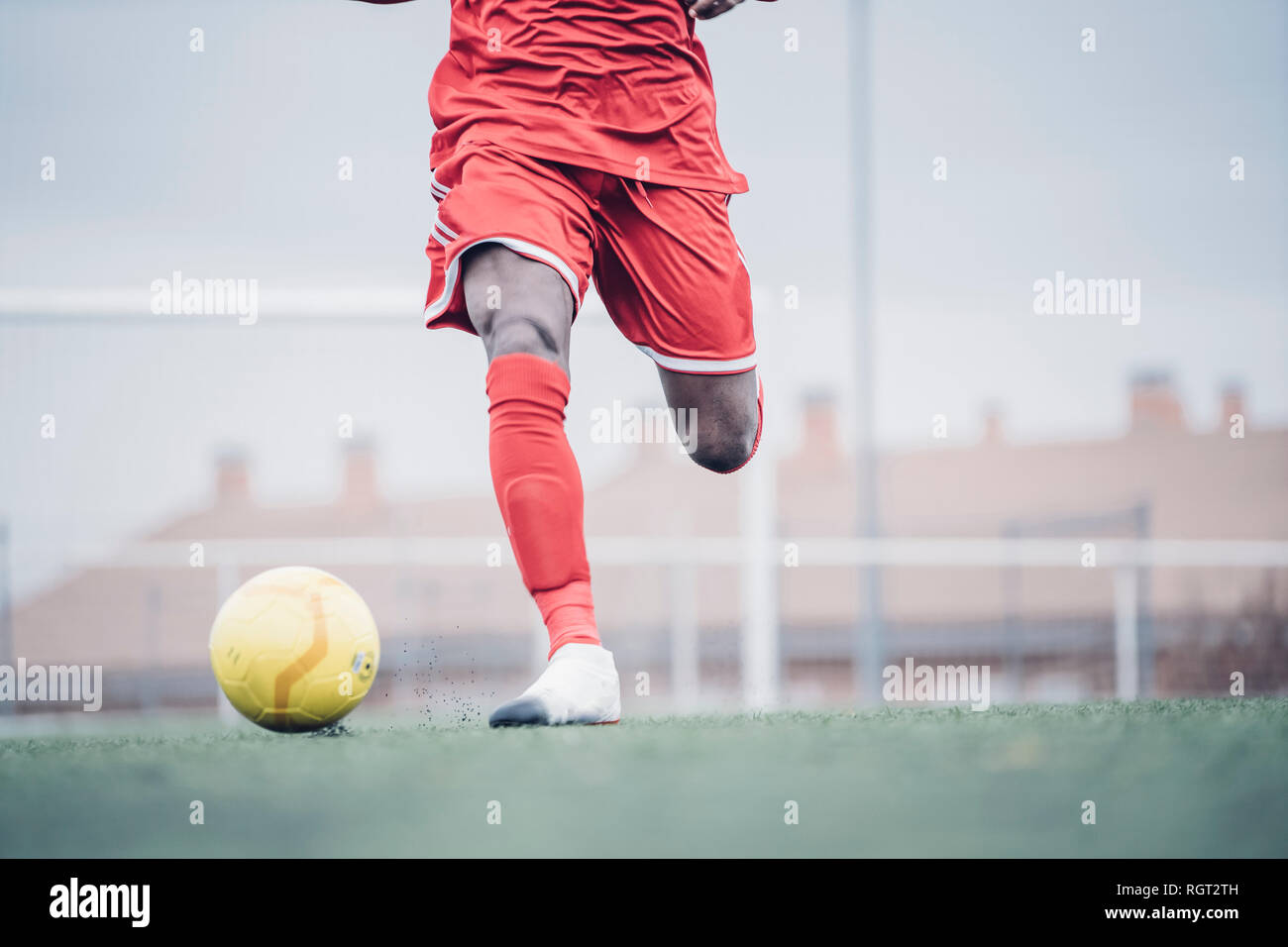 African soccer player with red outfit playing soccer Stock Photo - Alamy