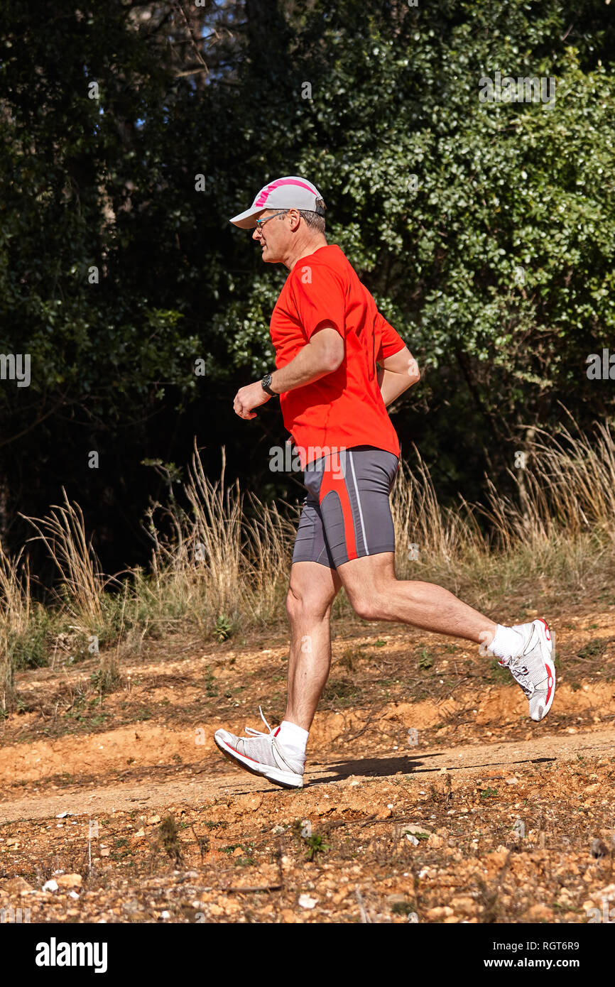 Young runner running in red t-shirt at springtime Stock Photo - Alamy