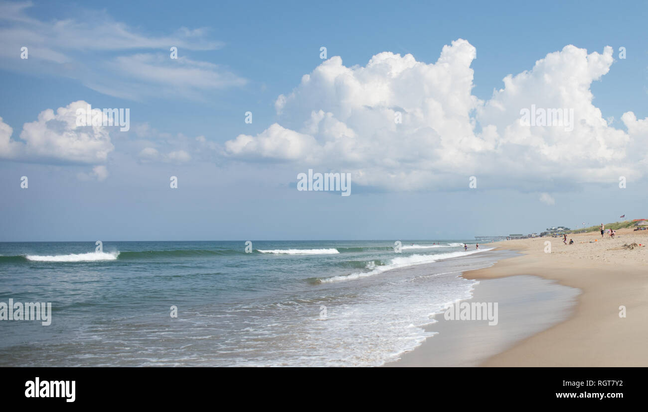 A photo of the shoreline with a pier far off in the distance and ...