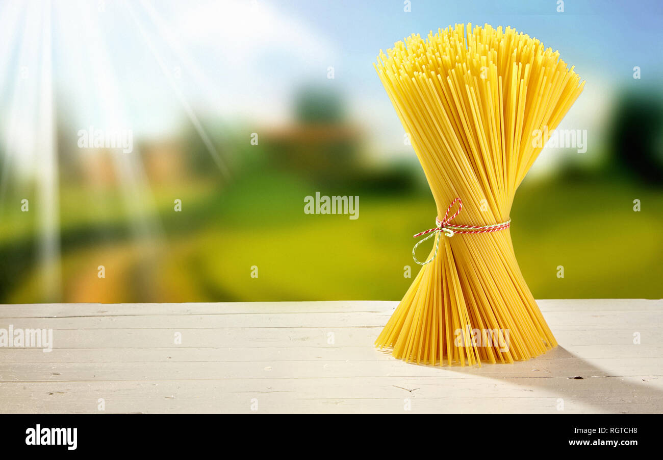 Twisted bundle of dried Italian spaghetti standing upright outdoors on ...