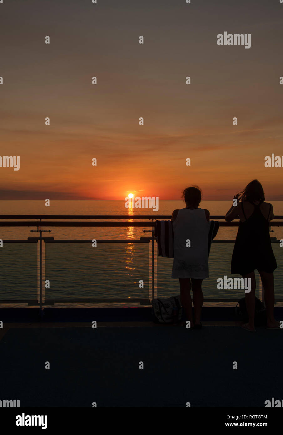 Two people watching orange sunset hi-res stock photography and images ...