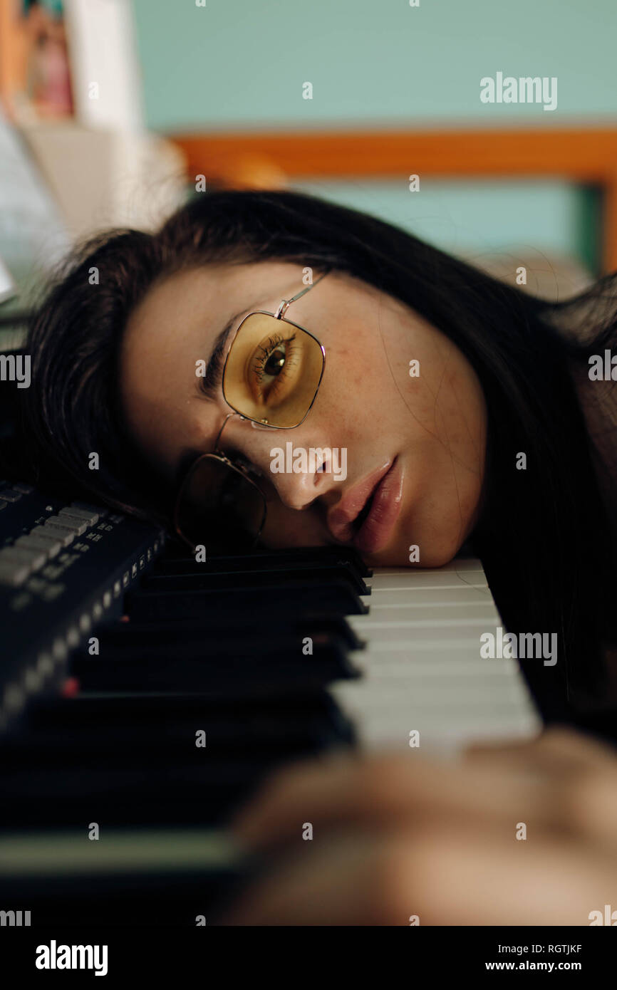 Head of attractive young tired lady in sunglasses looking at camera and ...