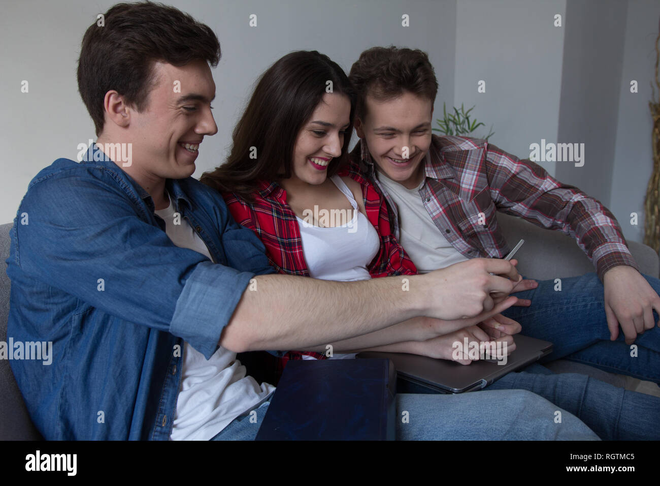 Group of friends sitting on couch Stock Photo - Alamy
