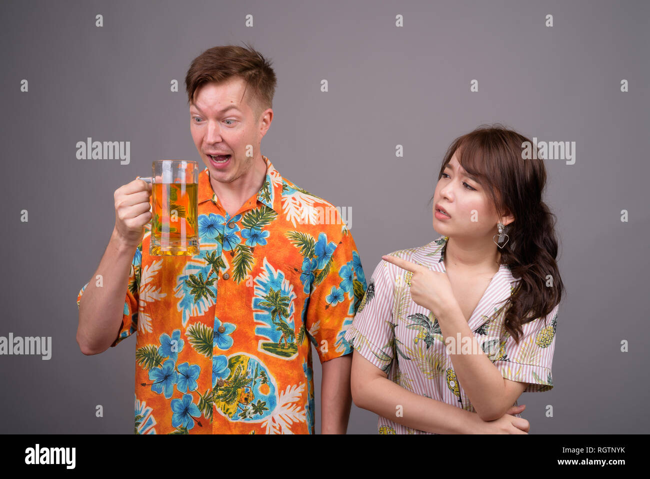 Woman looking angry while boyfriend is drinking beer Stock Photo - Alamy