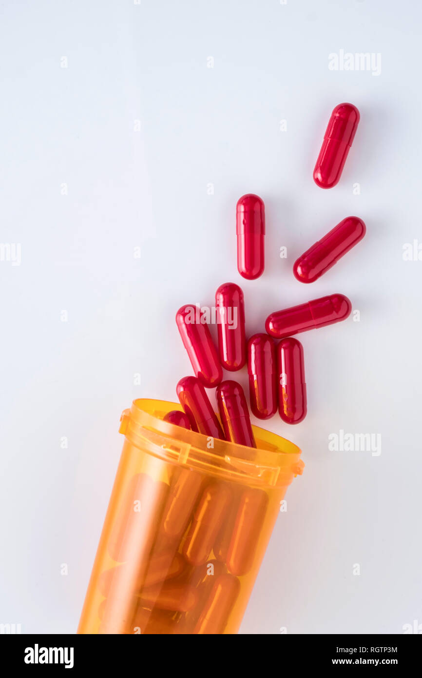 capsules going out of a bottle, conceptual image, vertical composition ...