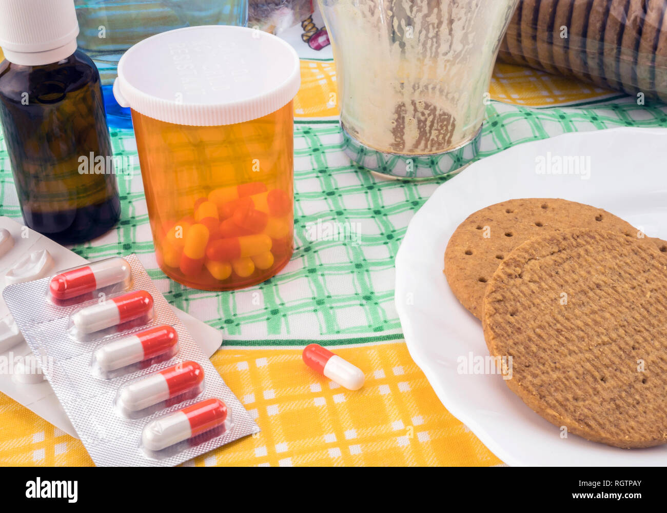 Medication during breakfast, capsules next to a glass of water ...