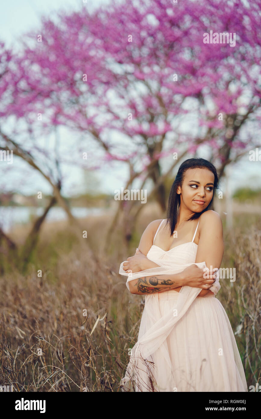 African-American young woman, the trees with the lovely pink color ...