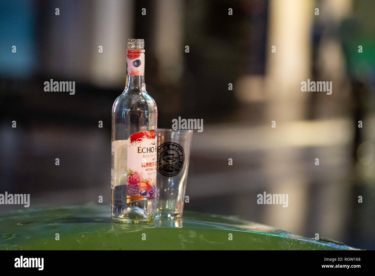 An empty bottle of Echo Falls alcohol on a bin lid at night in Cardiff ...