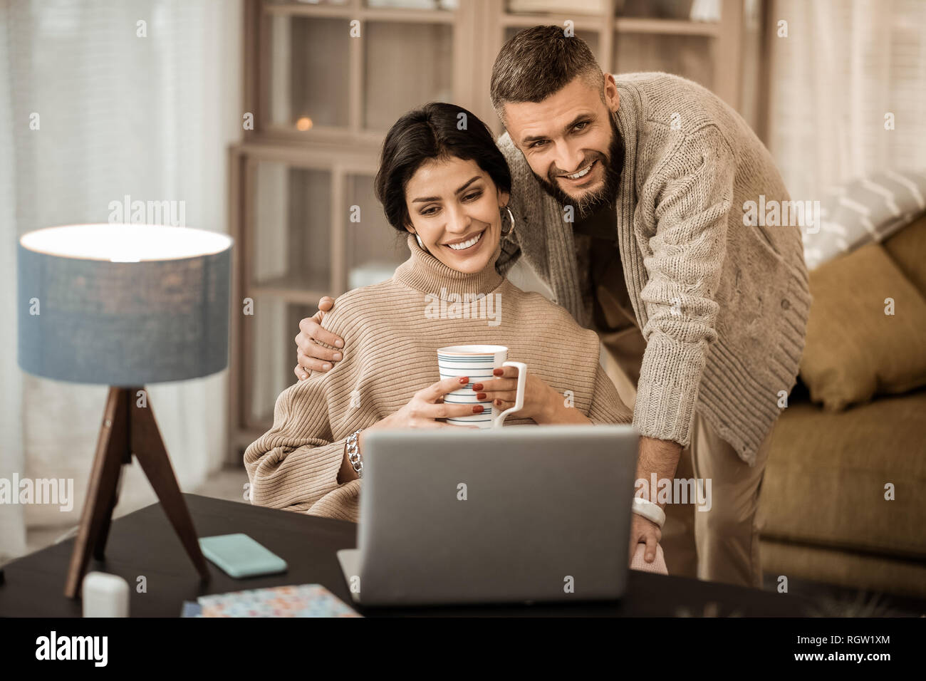 Peaceful good-looking couple spending time together in cabinet Stock ...