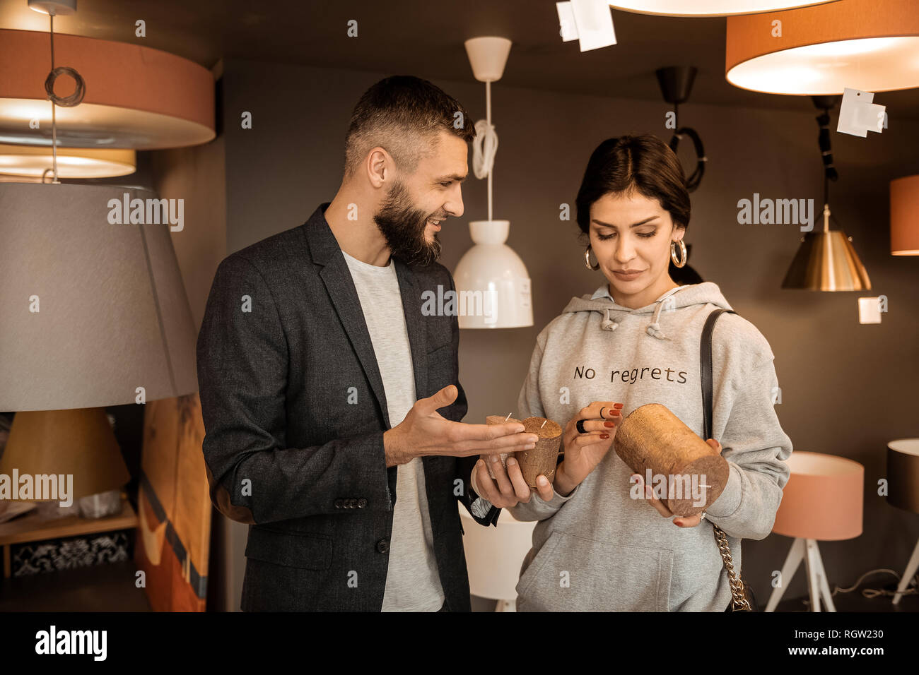 Curious couple carrying brown candles and discussing their ...