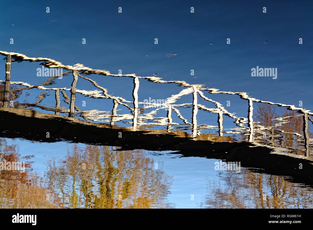 Reflection of a footbridge over water Stock Photo - Alamy