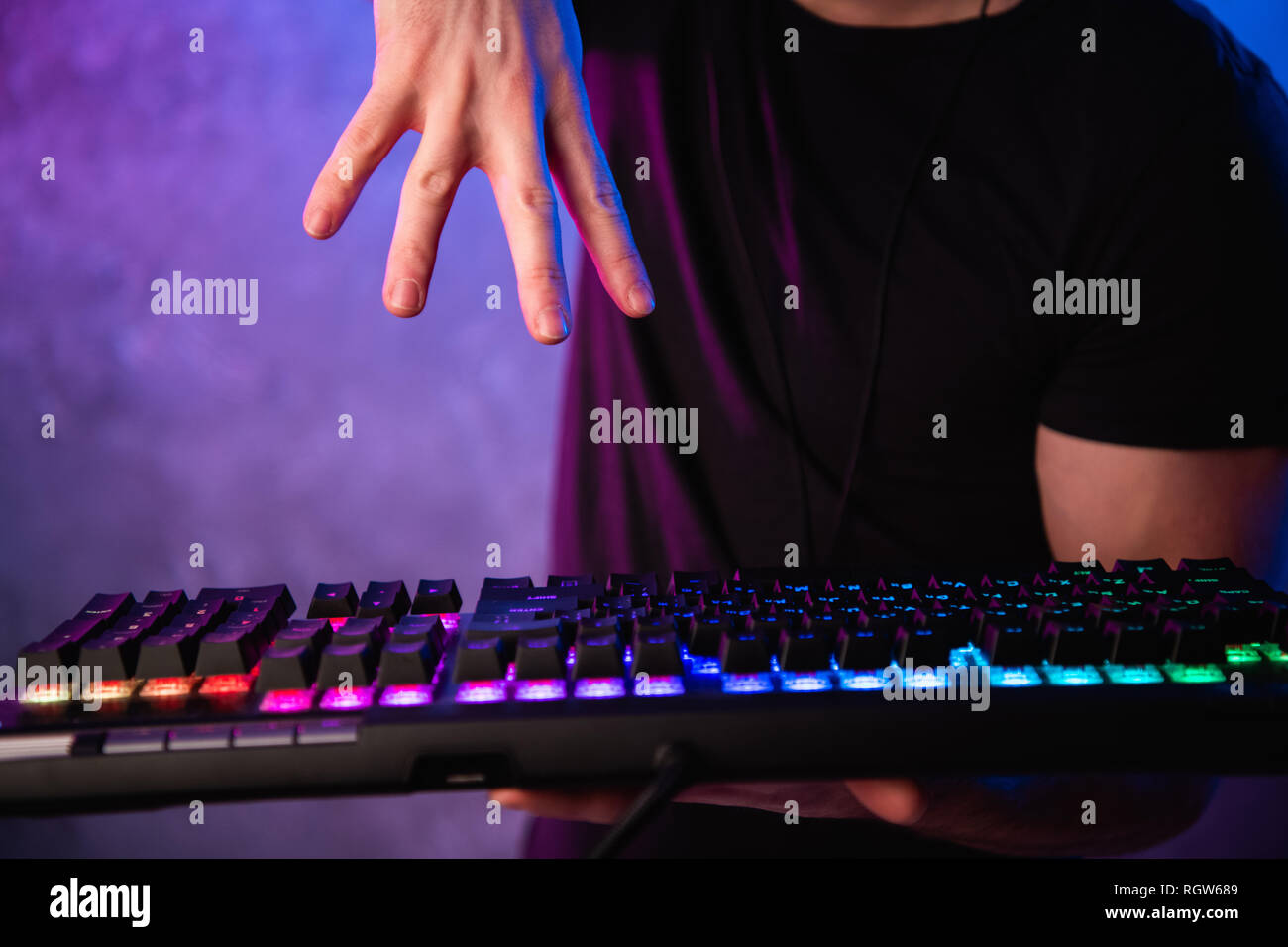 Close-up on gamer's hands going to press a key on a keyboard ...
