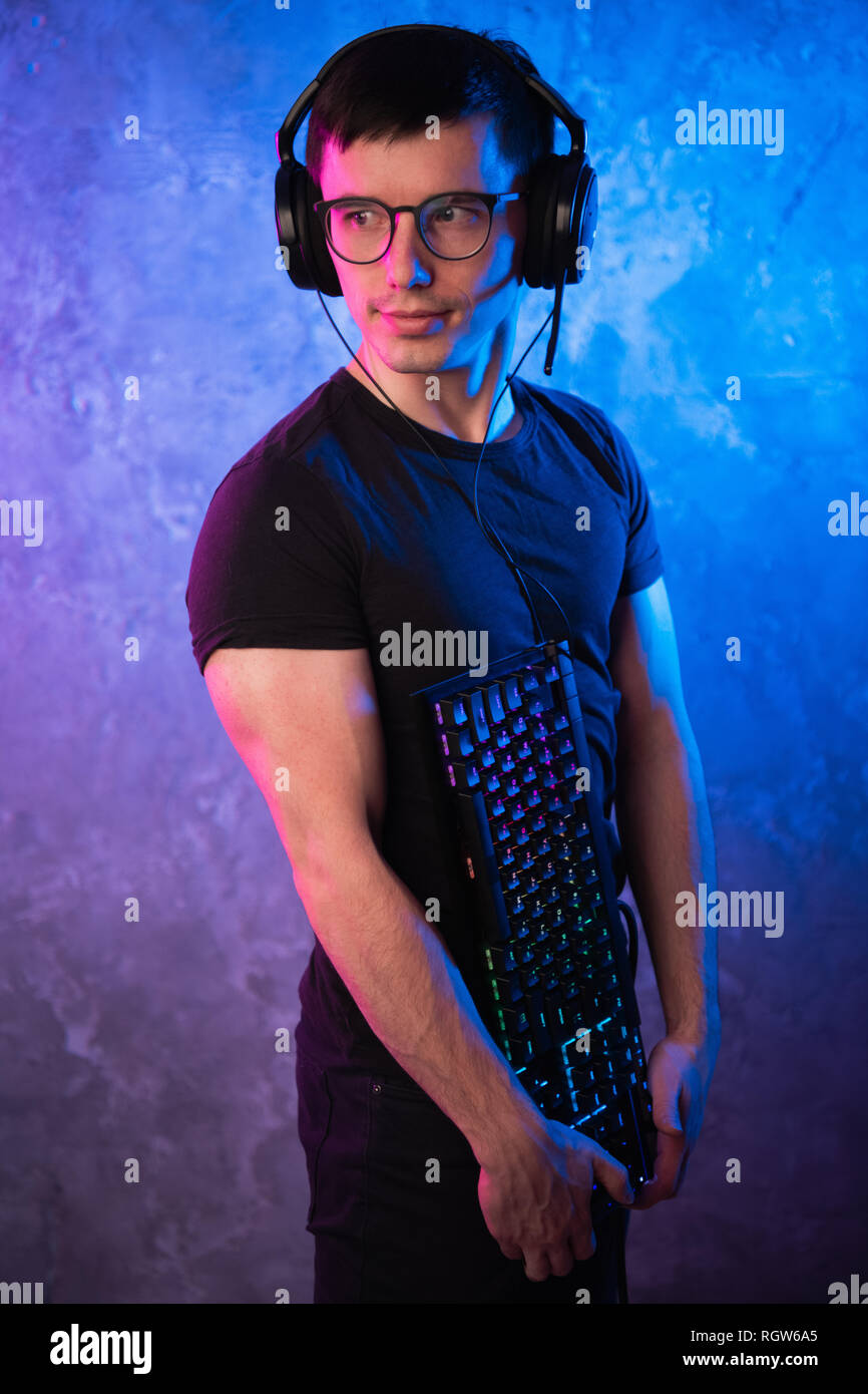 Professional Boy Gamer holding gaming keyboard over colorful pink and ...