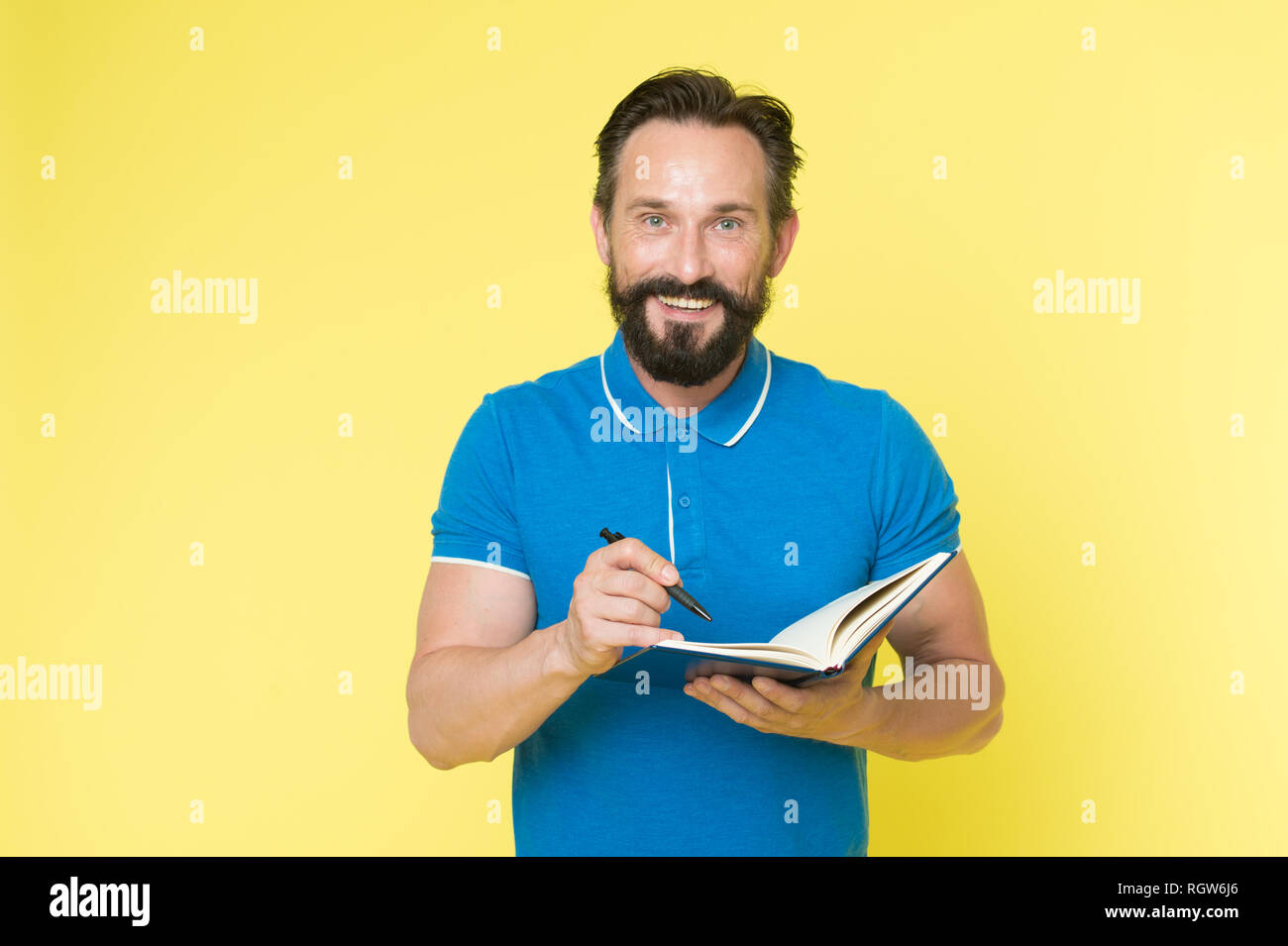 Man mature bearded guy writing notes to notepad. Check what is done ...