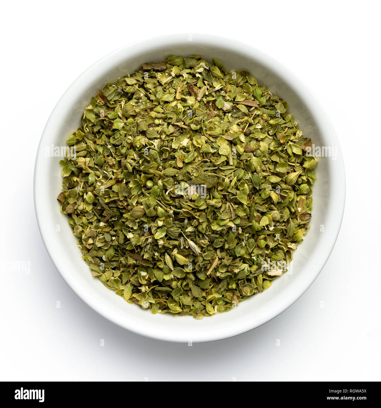 Dried chopped oregano in white ceramic bowl isolated on white from ...