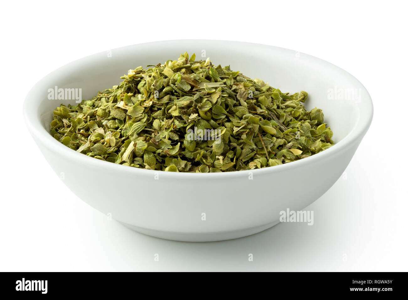 Dried chopped oregano in white ceramic bowl isolated on white Stock ...