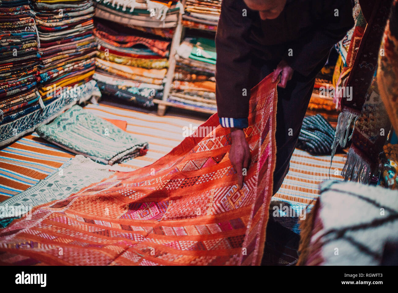 Crop seller showing traditional red bright carpet in the market in ...