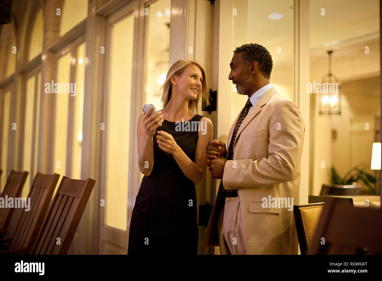 Two business partners talking on the balcony of their hotel Stock Photo ...