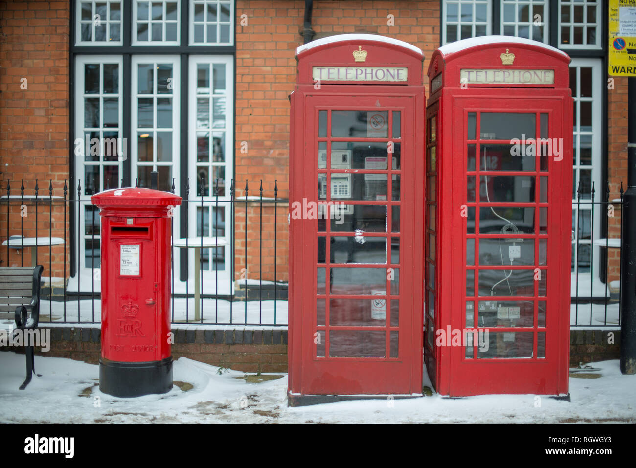 bright red phone and post boxes in snow in typical British winter scene ...