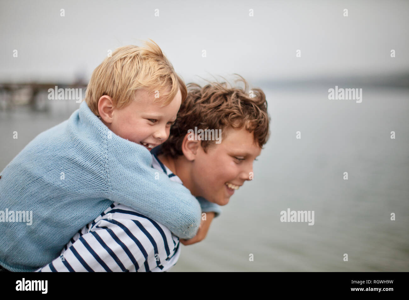 Young boy getting a piggy-back from his older brother Stock Photo - Alamy
