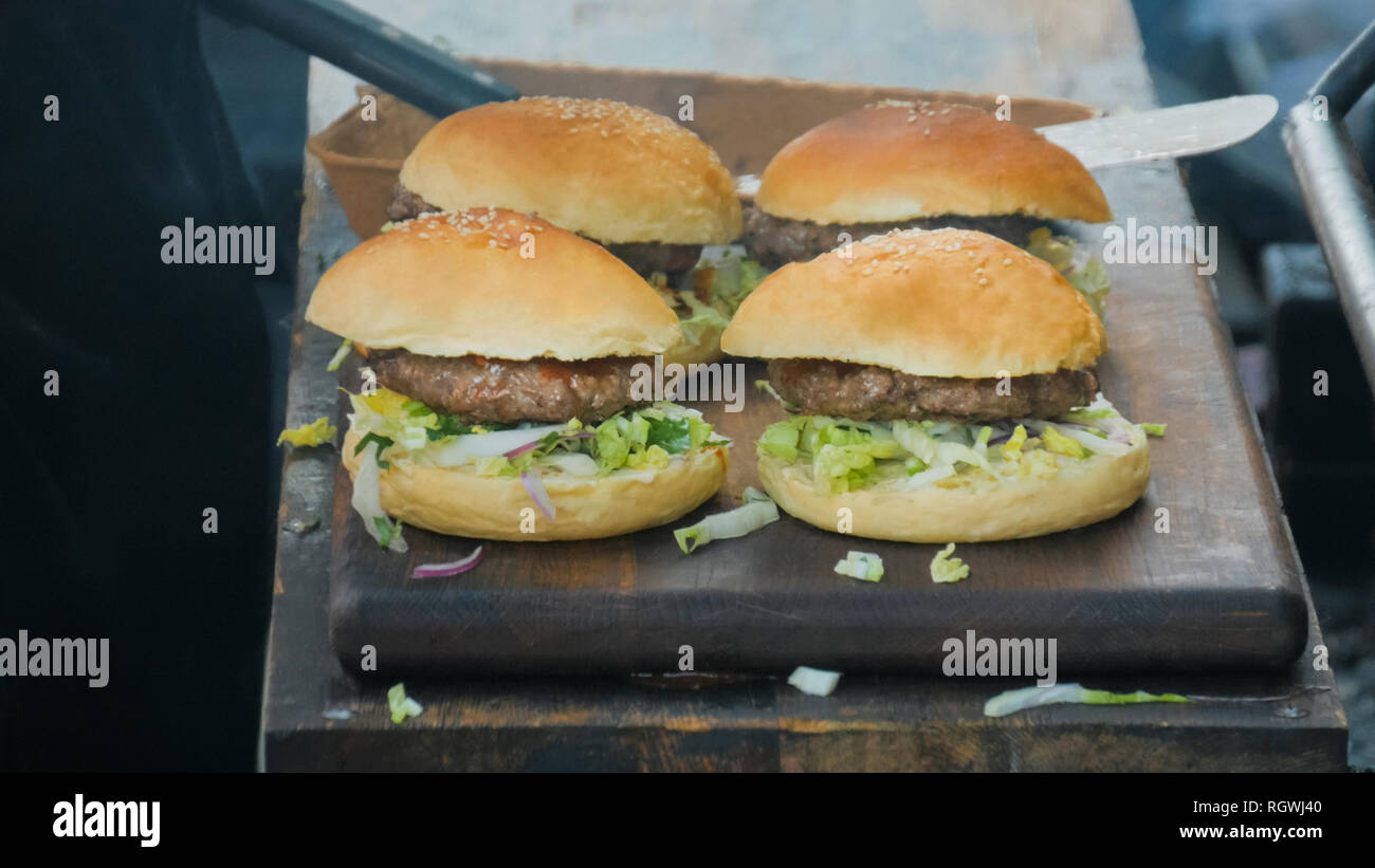 Process of preparing burgers at street food festival. Outdoor cooking ...