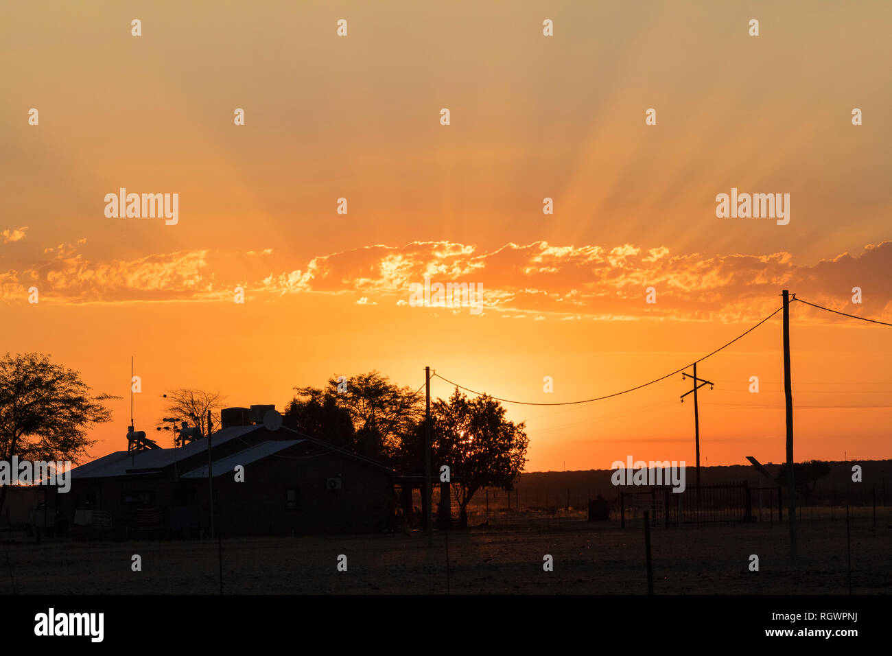 Spectacular fiery orange African sunset with divergings rays behind a ...