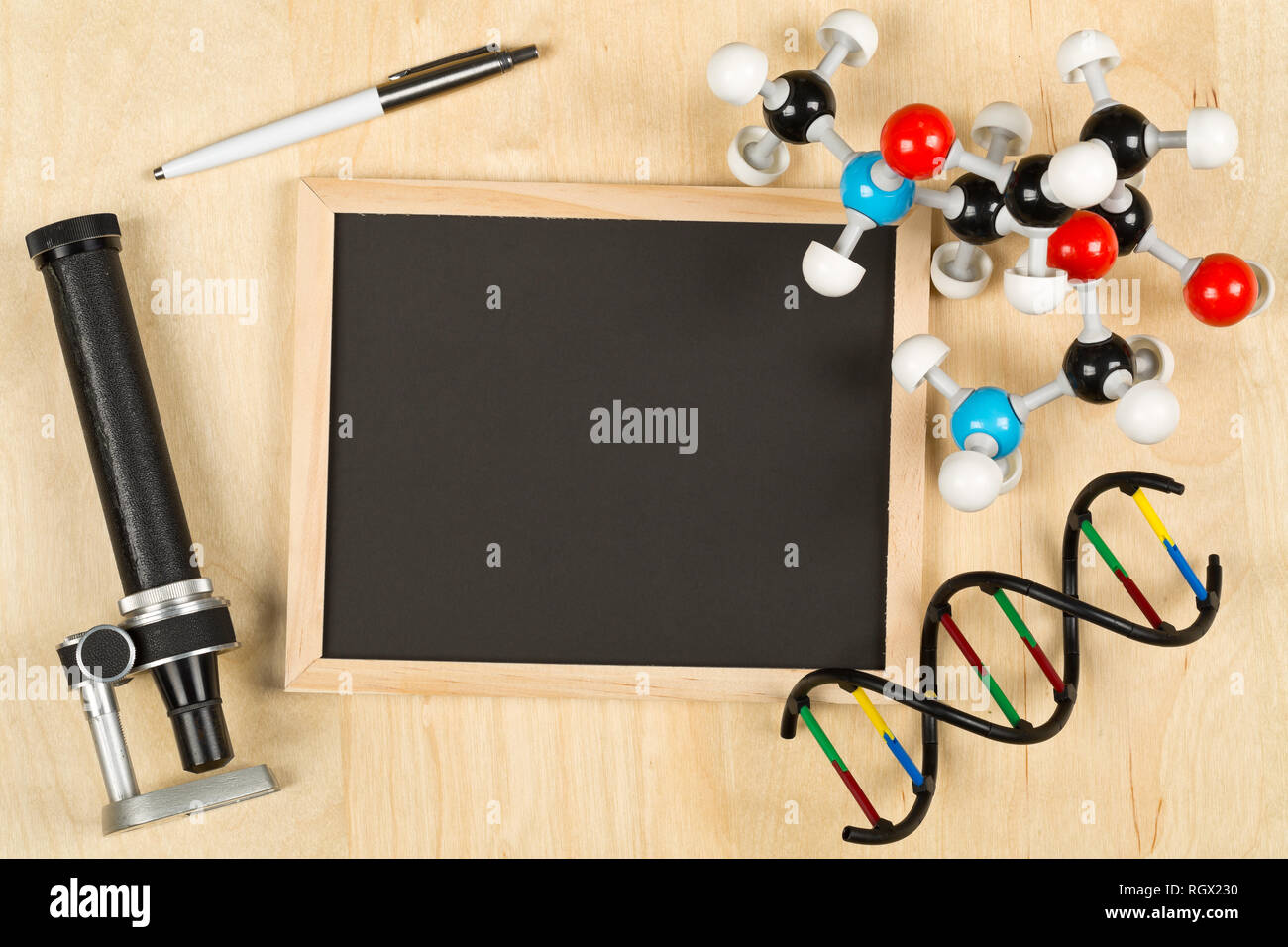 Blank, empty, black chalkboard with microscope, molecule model, pen and ...