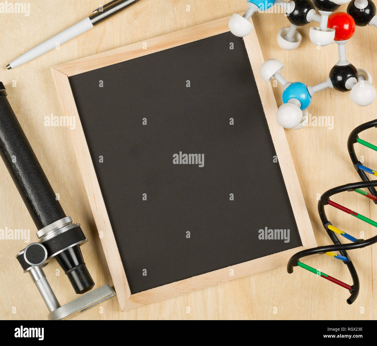 Blank, empty, black chalkboard with microscope, molecule model, pen and ...