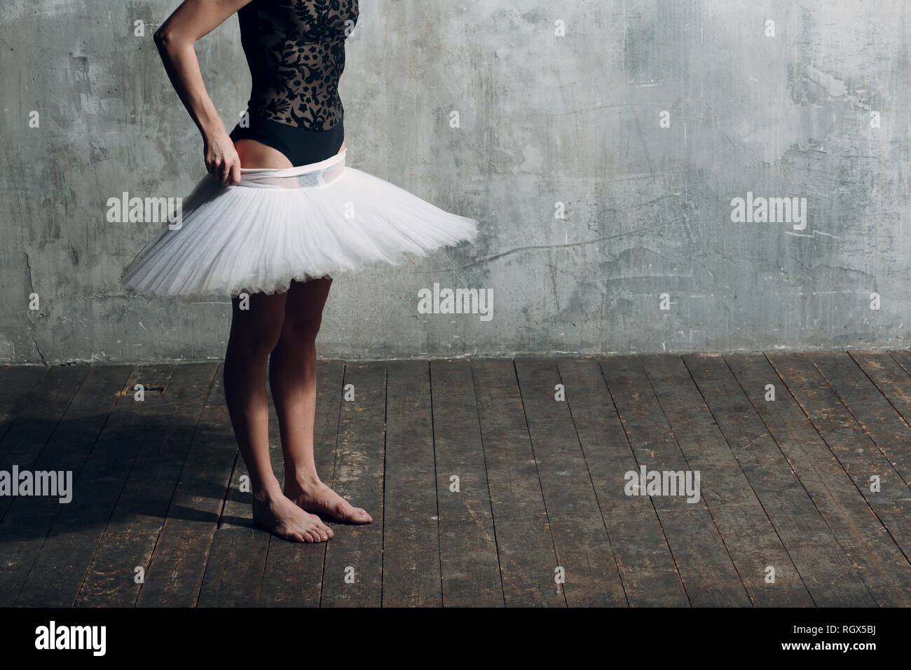 Ballerina putting on white tutu. Young beautiful woman ballet dancer ...